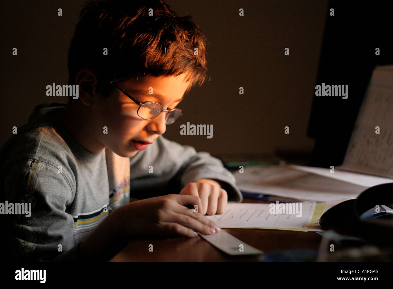 Lifestyle portrait of a primary school boy as he is doing his homework ...