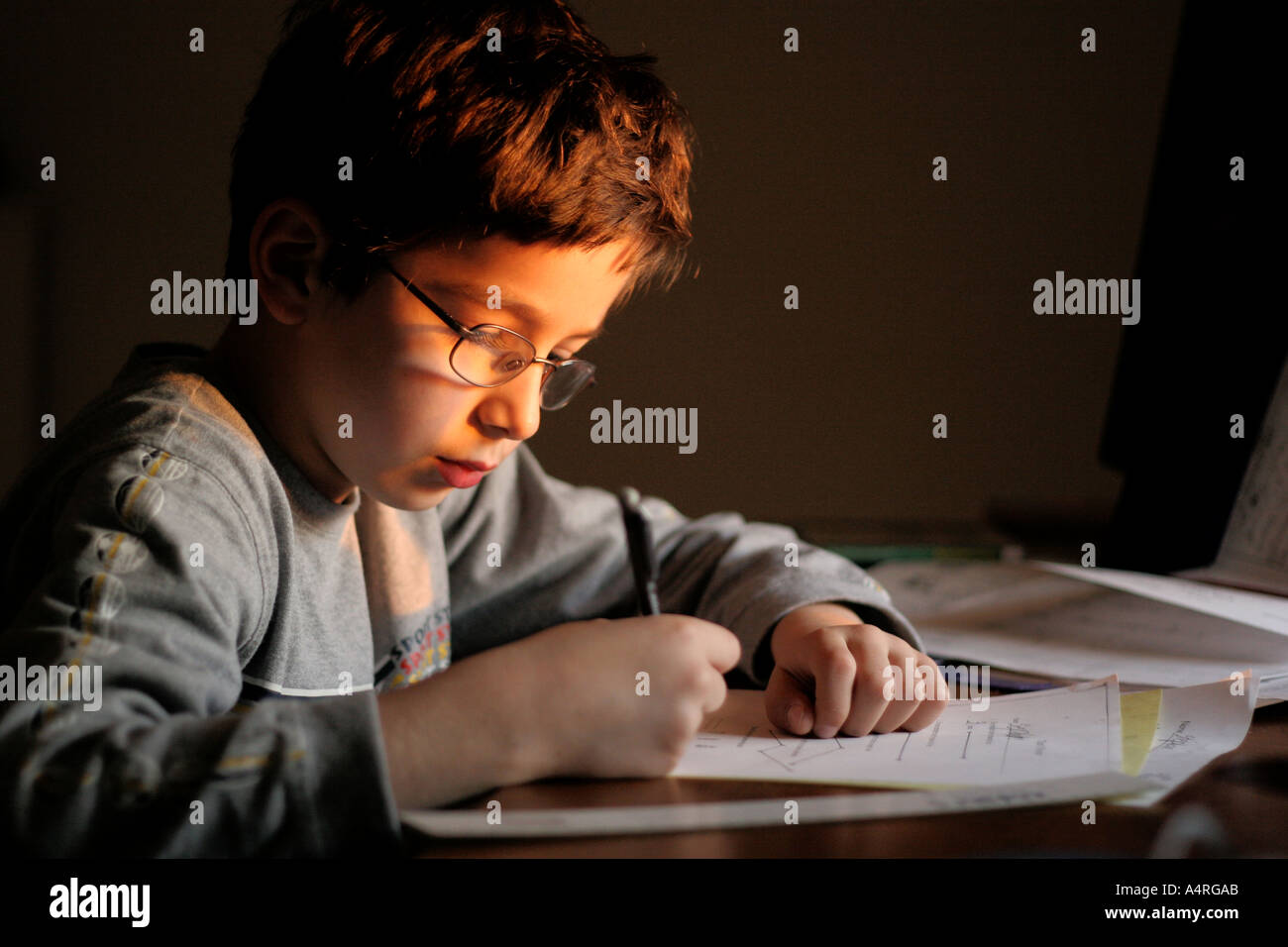 Lifestyle portrait of a primary school boy as he is doing his homework ...