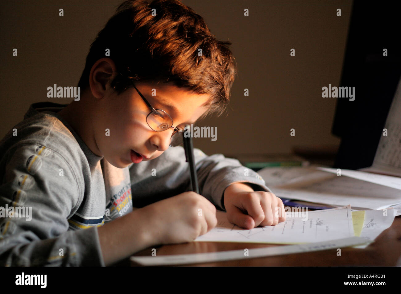 Lifestyle portrait of a primary school boy as he is doing his homework ...