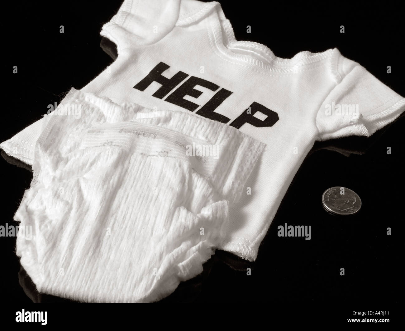 Pemature baby shirt and diaper with a coin to demonstrate the scale ...
