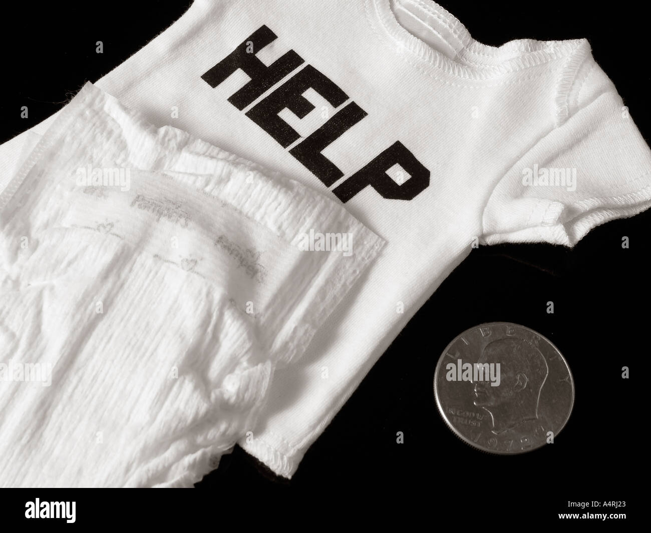 Pemature baby shirt and diaper with a coin to demonstrate the scale ...