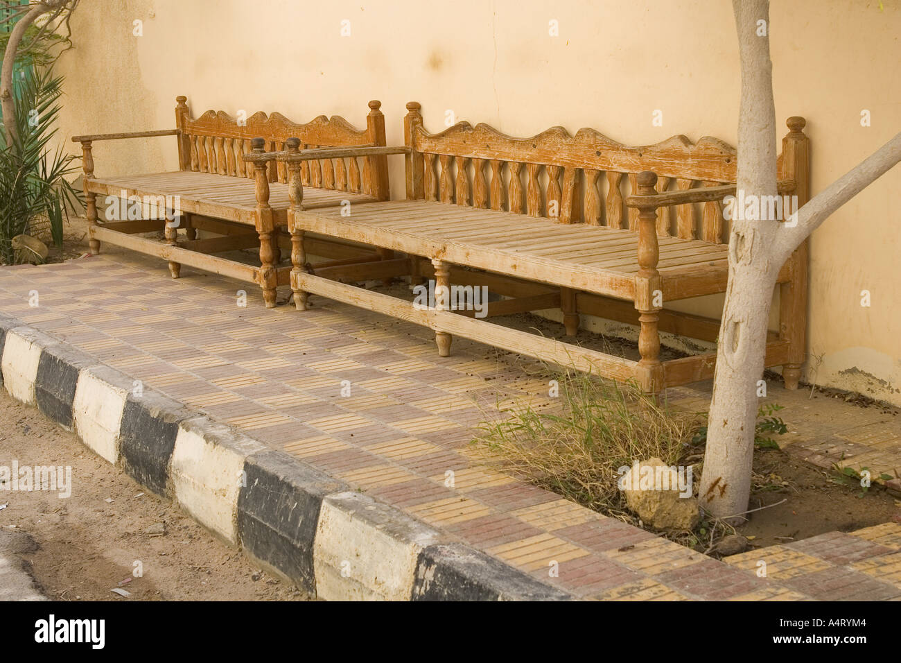 Wooden bench against a wall Stock Photo - Alamy