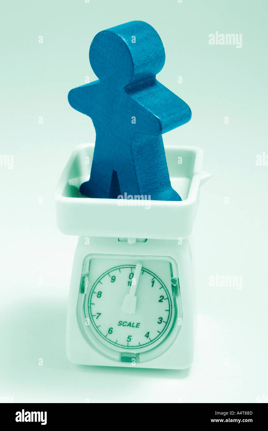 Wooden Child Figure on Weighing Scale Stock Photo - Alamy