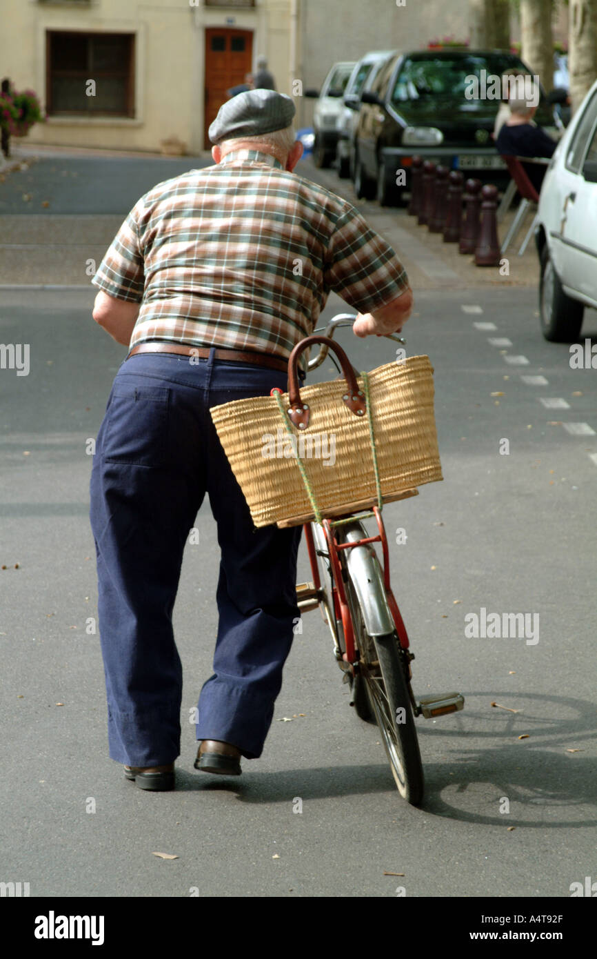Old man with cycle in Capestang a small town in a wine growing region ...