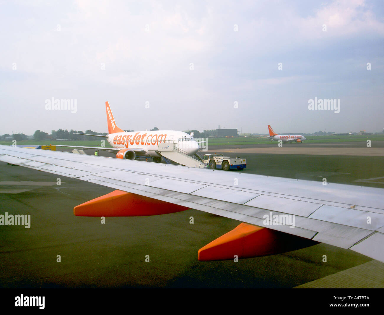 Three Easyjet livery short haul aircraft on airport apron and runway ...