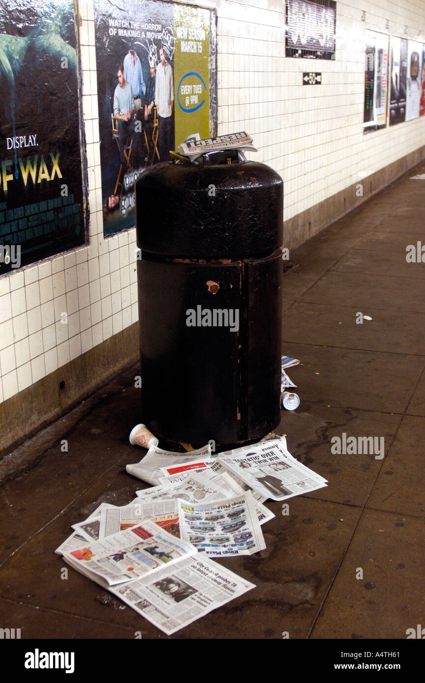 An overflowing trash recepticle in the West 50th St NYC subway station ...