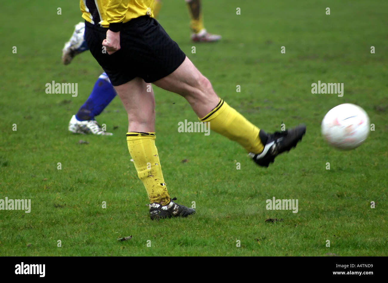 Footballer kicking a ball Stock Photo - Alamy