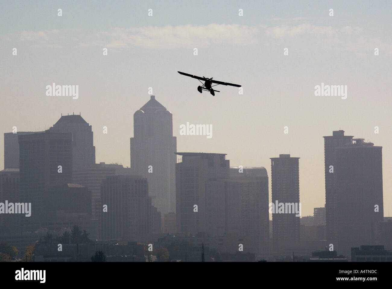 A Kenmore Air seaplane flys over the Seattle skyline to Lake Union in ...