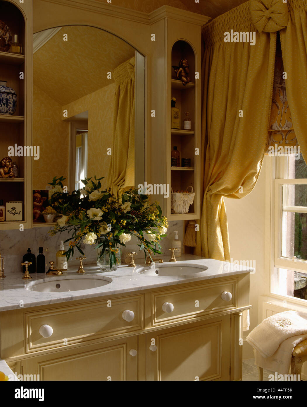 Close-up of underset double basins beside window with yellow drapes ...