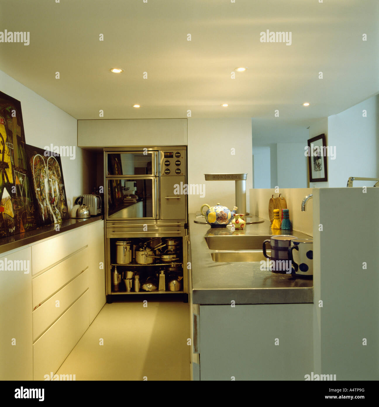 Compact modern kitchen with chrome worktops and downlighting Stock ...