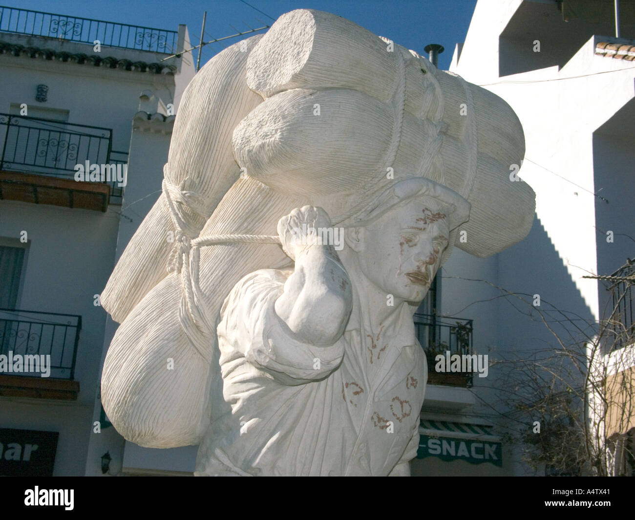 White marble statue Mijas Pueblo man carrying burden defaced with ...