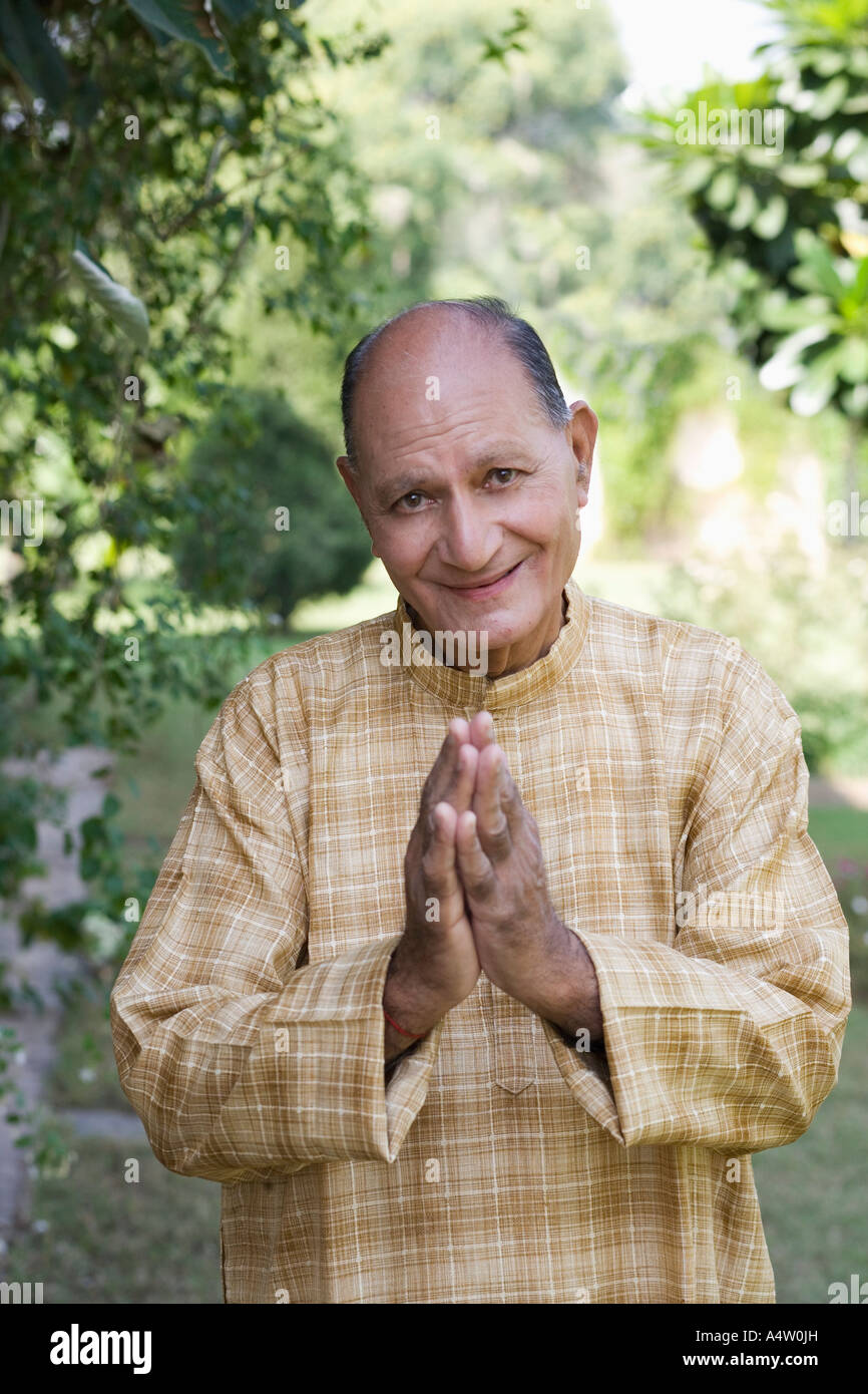 Man pressing hands together in praying position outdoors Stock Photo ...