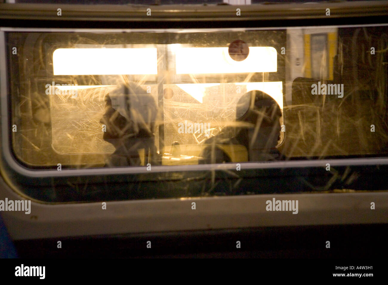 passengers on a train photographed through grafitti on window Stock ...