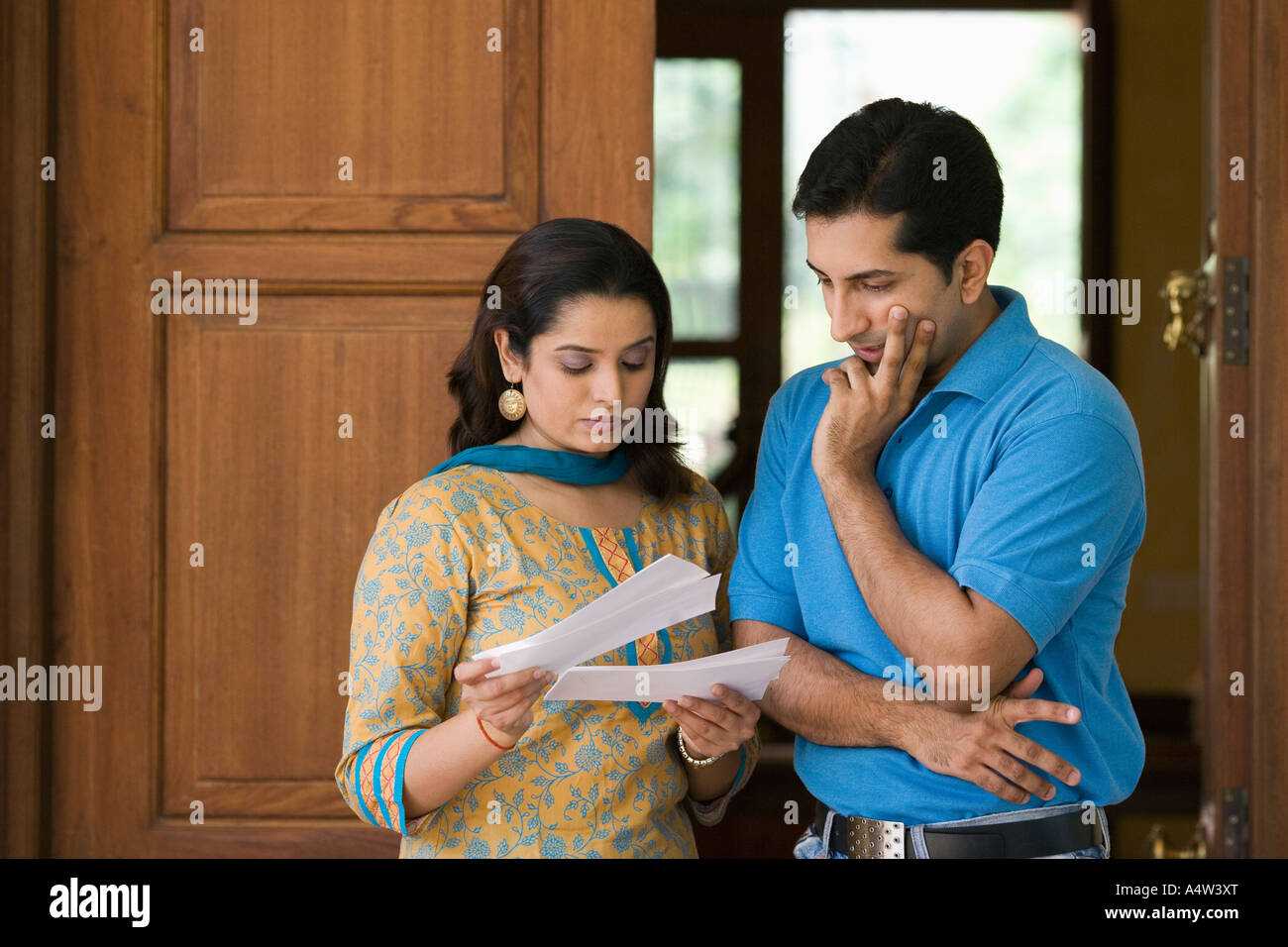 Couple reading mail in doorway Stock Photo - Alamy