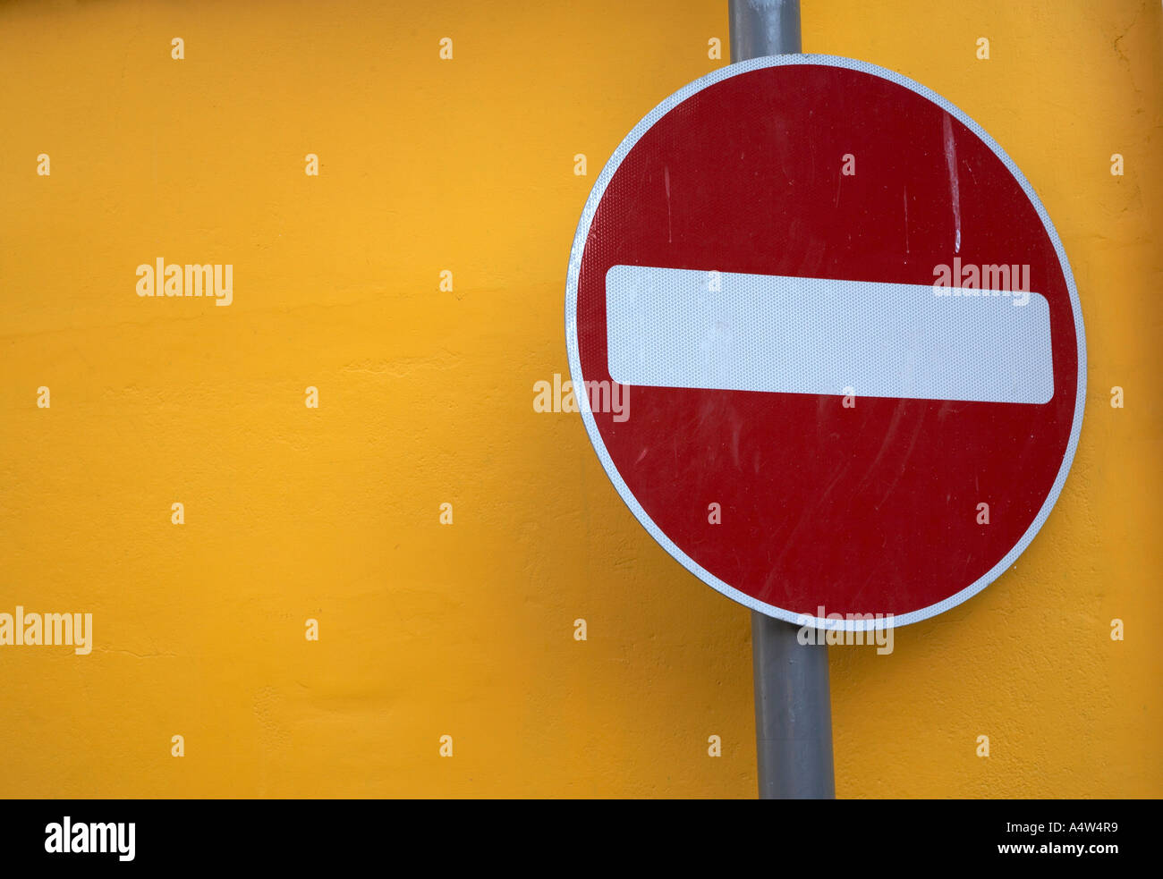 Highway stop sign and yellow wall England Stock Photo - Alamy