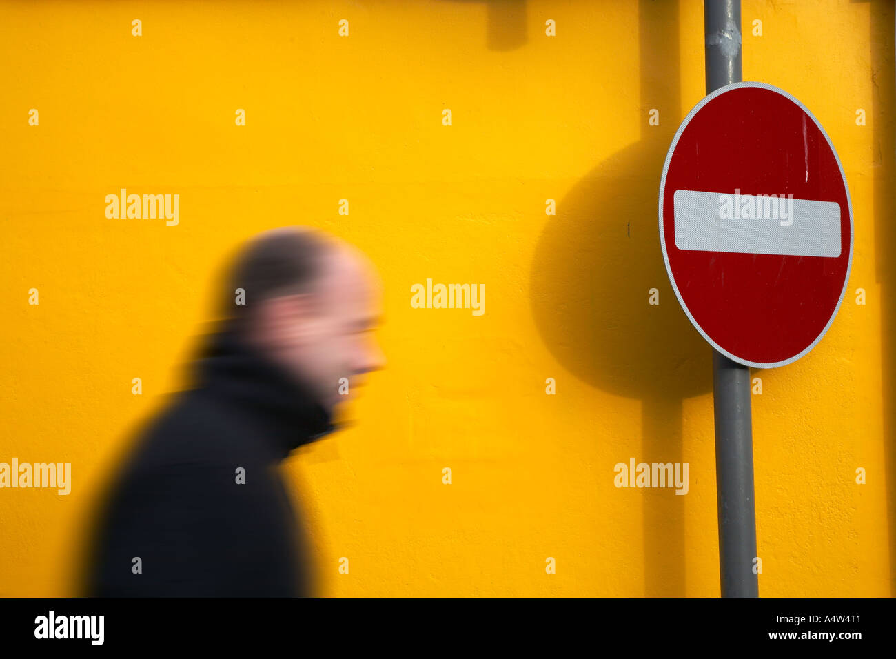Highway stop sign and yellow wall England Stock Photo - Alamy
