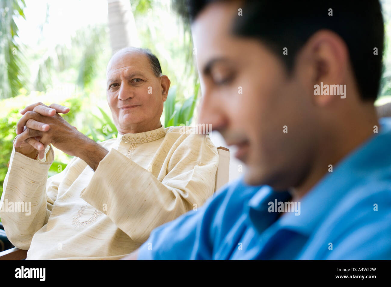 Man sitting with hands folded Stock Photo - Alamy