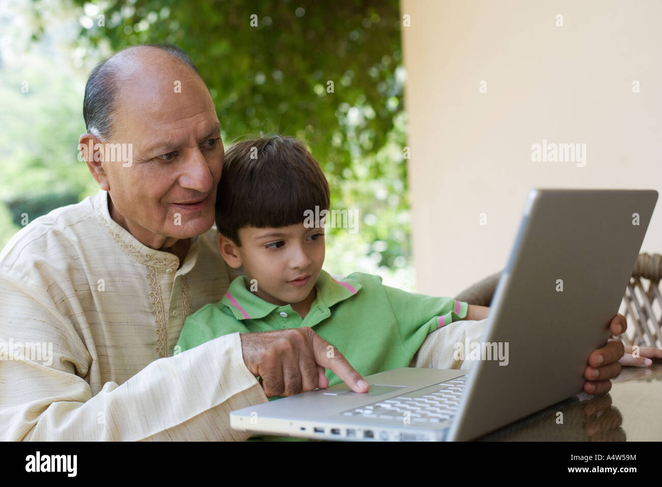 Grandfather using a laptop with his grandson Stock Photo - Alamy