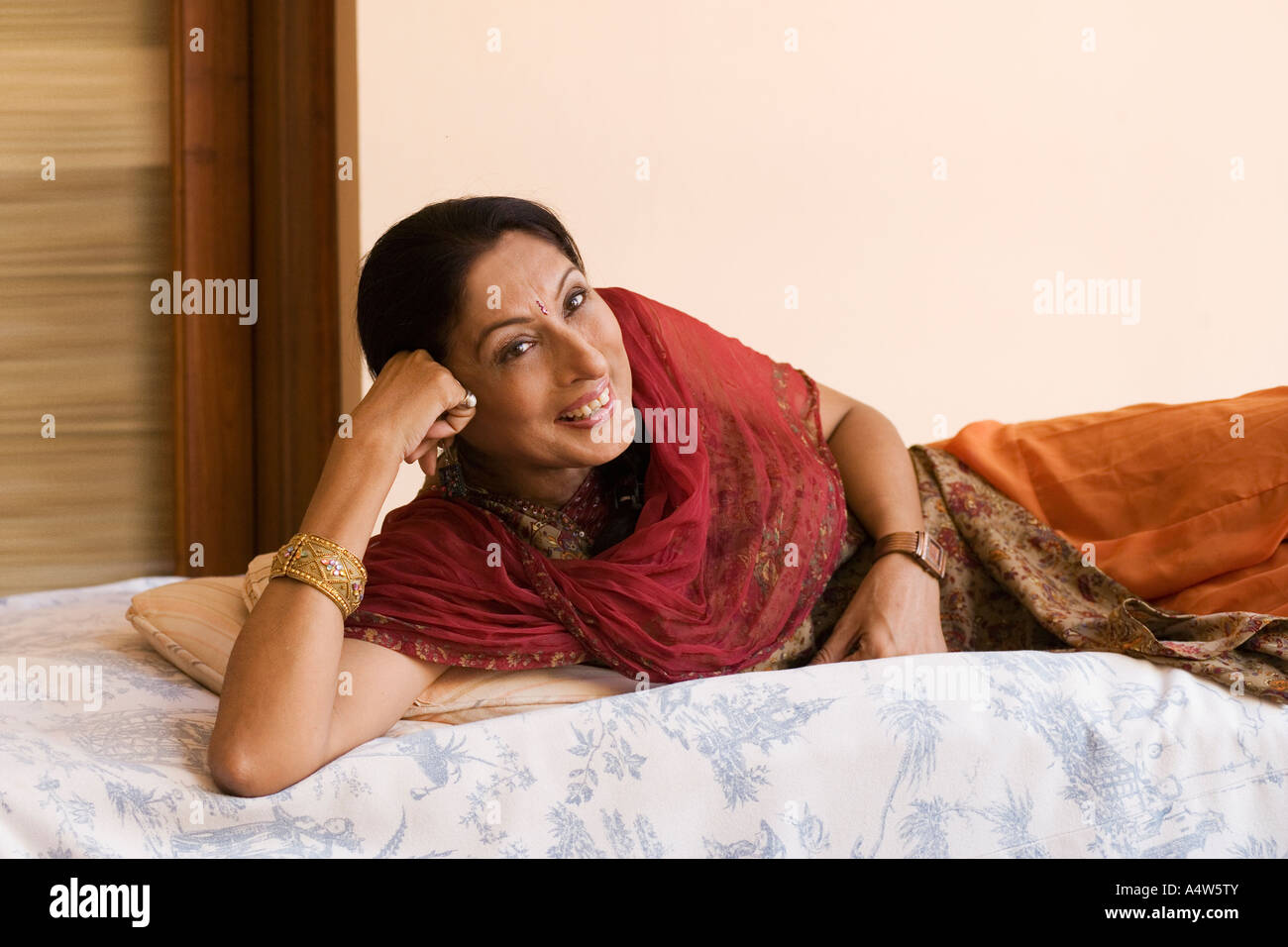 Woman reclining on bed Stock Photo - Alamy
