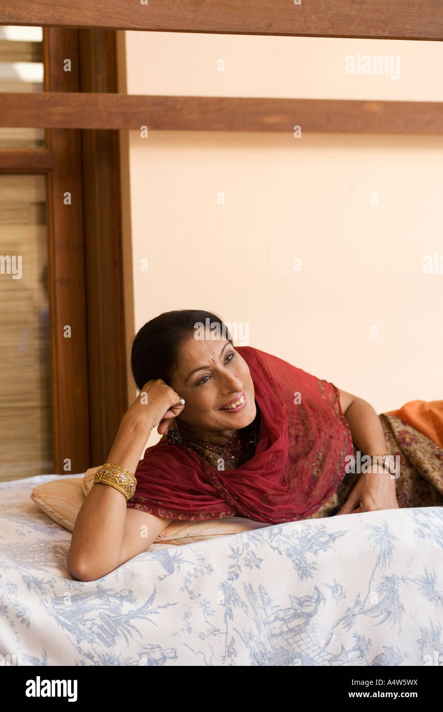 Woman reclining on bed Stock Photo - Alamy
