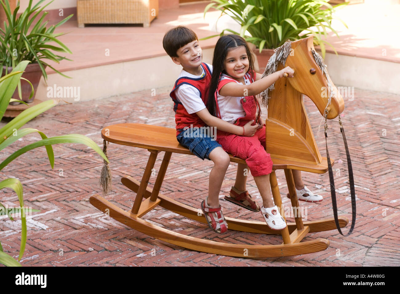 Children playing on wooden rocking horse Stock Photo - Alamy