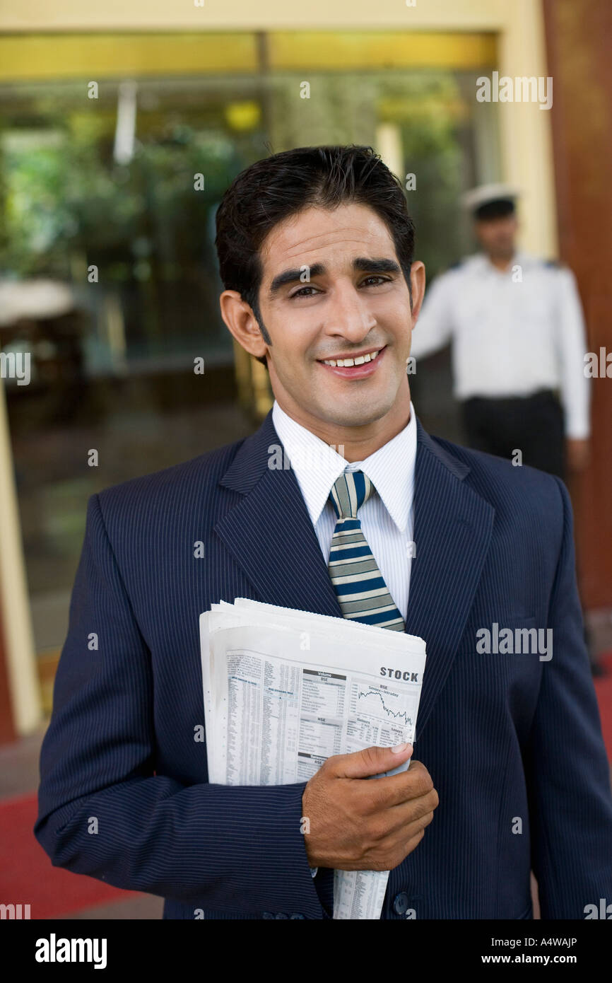 Businessman holding newspaper Stock Photo - Alamy