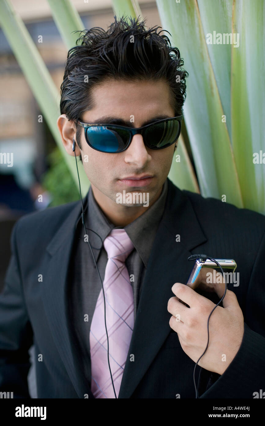 Businessman listening to mp3 player Stock Photo - Alamy