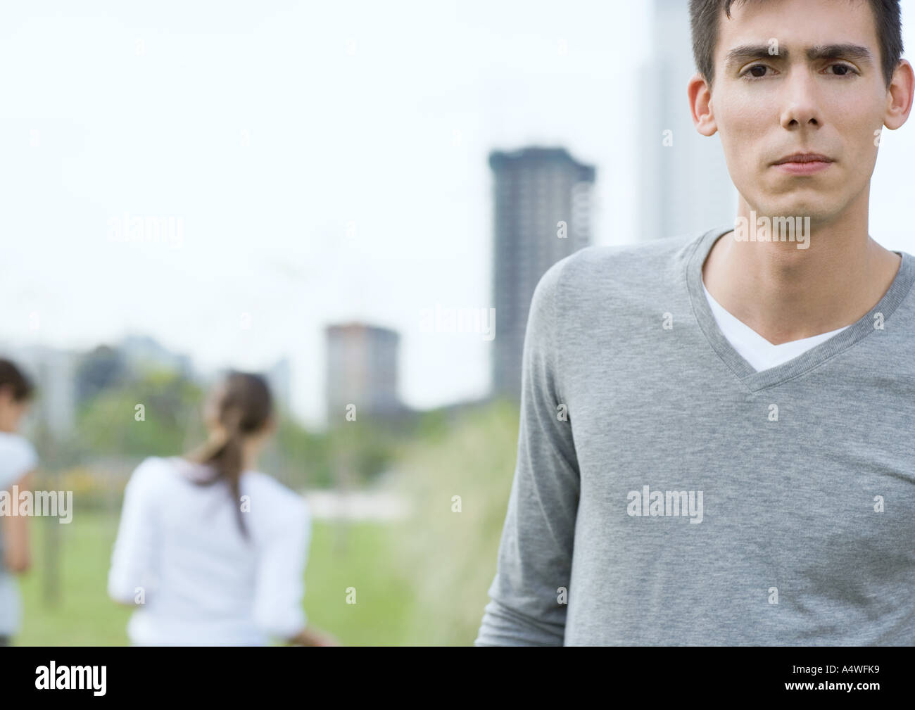 Young man frowning in urban park Stock Photo - Alamy