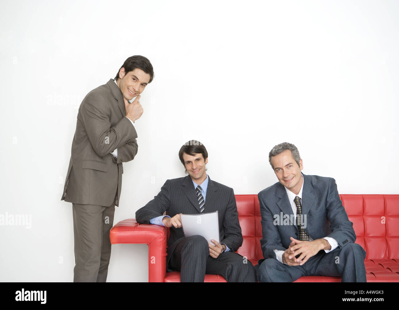 Three businessmen in office lobby Stock Photo - Alamy