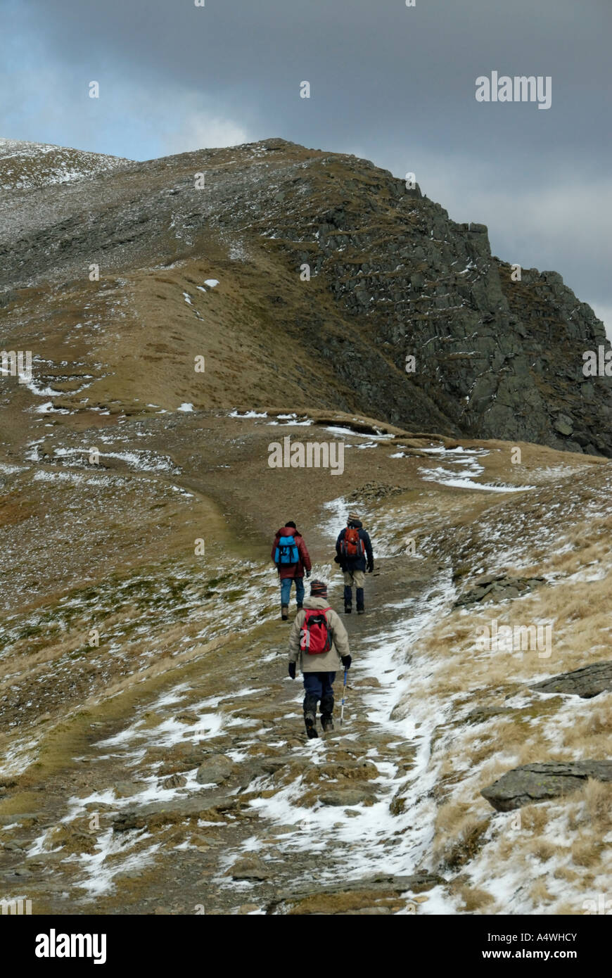 Walkers approaching the summit of Helvellyn in Winter. Lake District ...