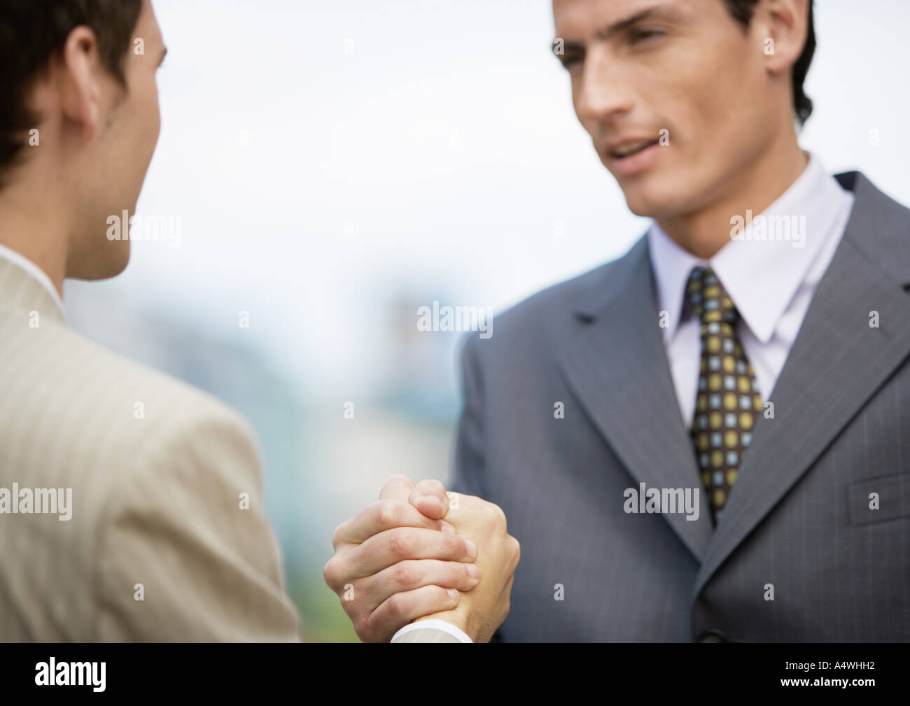 Two businessmen gripping hands Stock Photo - Alamy