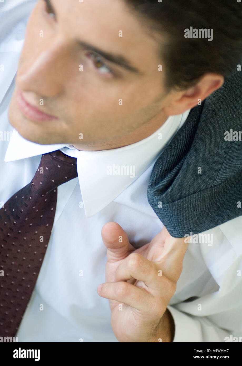 Businessman holding coat over shoulder Stock Photo - Alamy