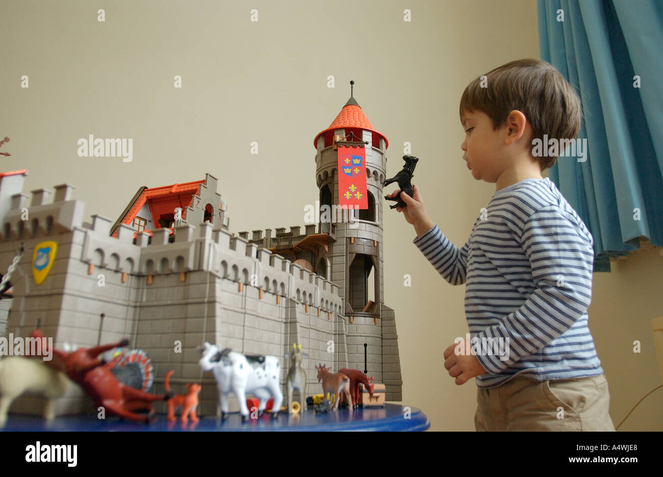 Little boy plays with a toy castle Stock Photo - Alamy