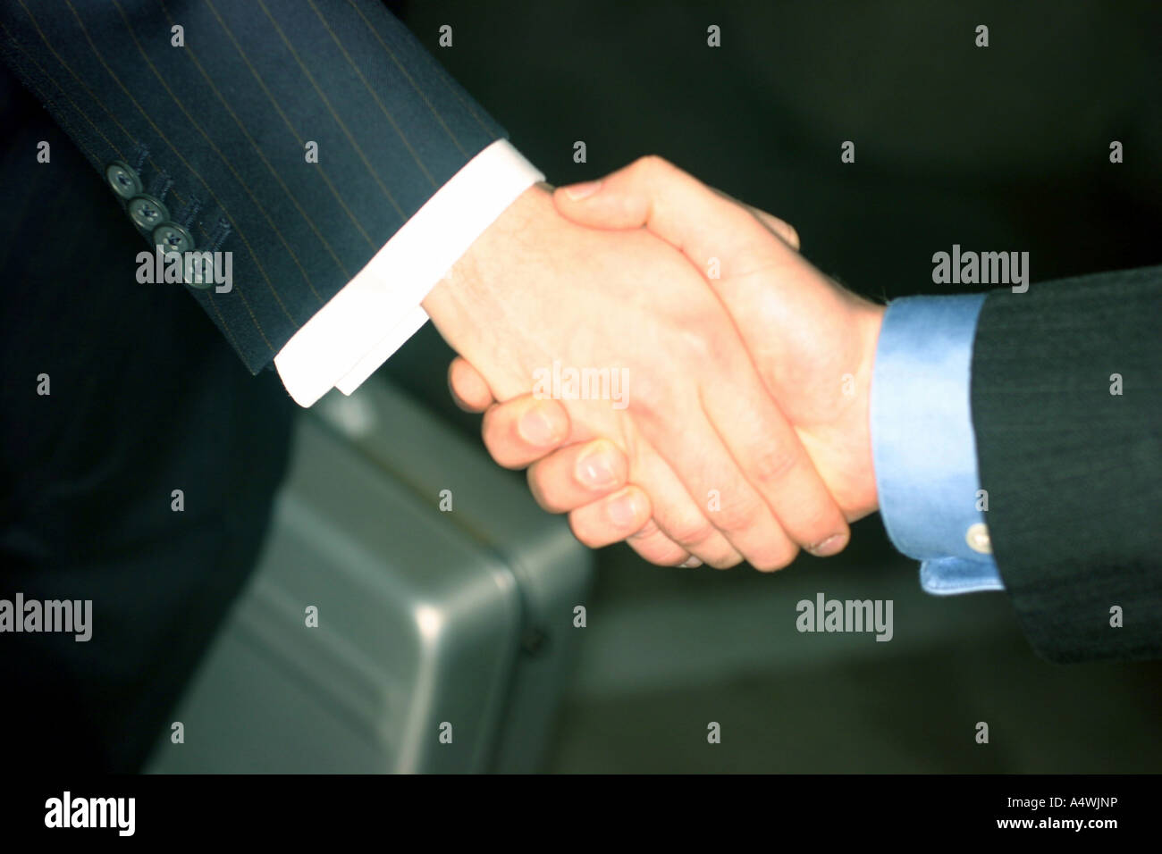 Businessmen give a handshake with a briefcase in the background Stock ...