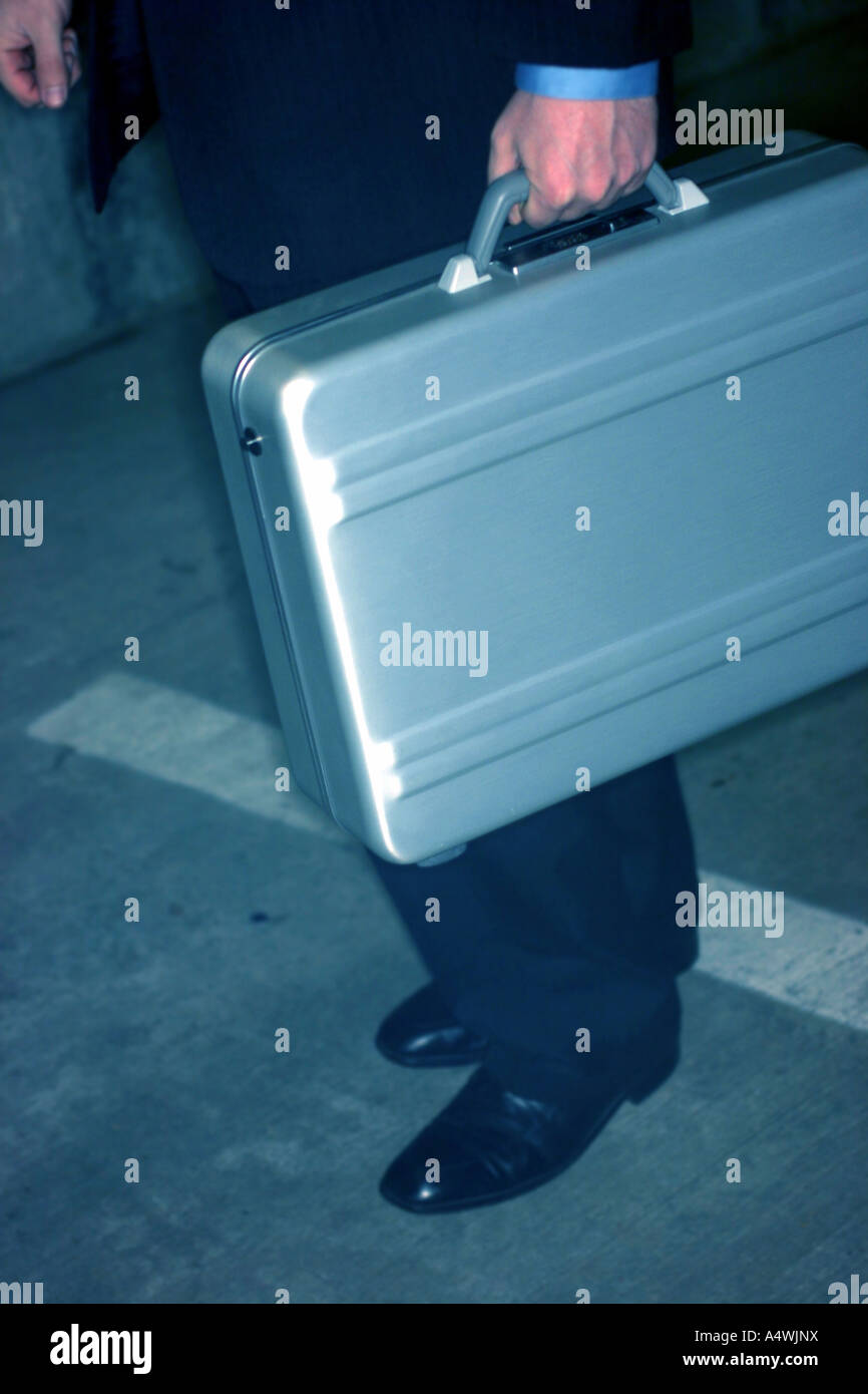 Businessman holding briefcase with his right hand as he wears a black ...