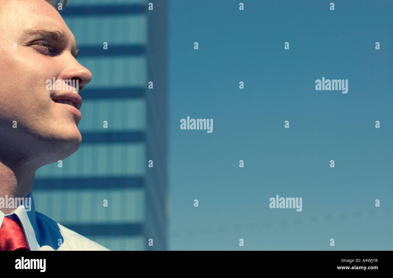Businessman profile looking out while standing outside in front of a ...