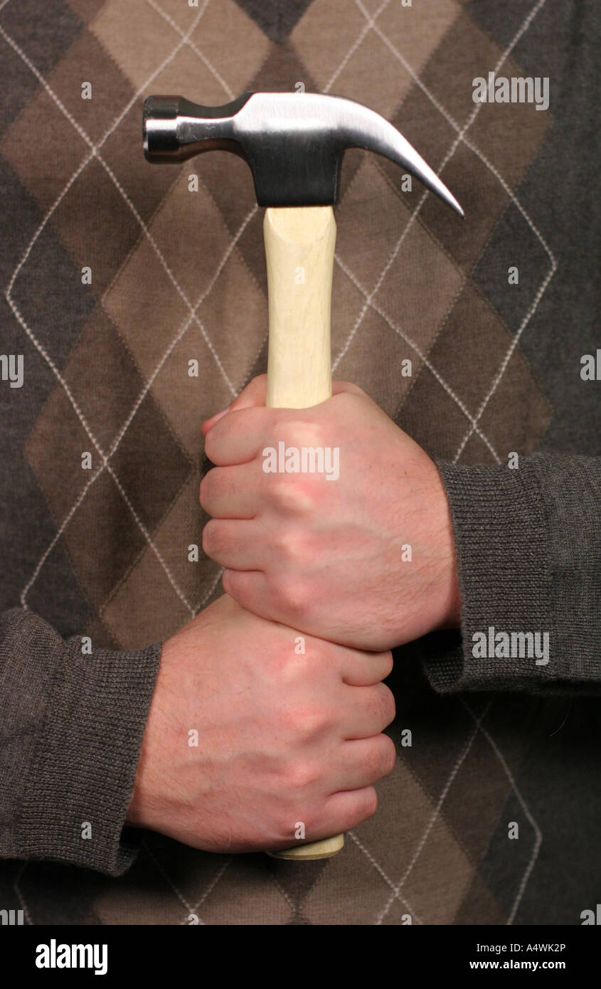 Man holding hammer with both hands in front of him while wearing a ...