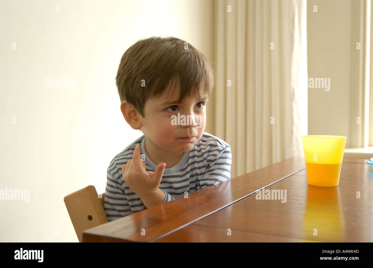 Little boy refuses to drink his juice Stock Photo - Alamy