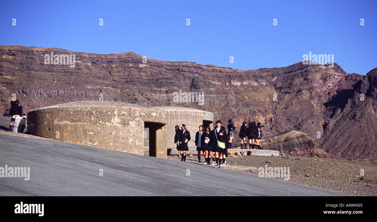 Japanese school girls next to a safety bunker next to Mount Aso, Japan ...
