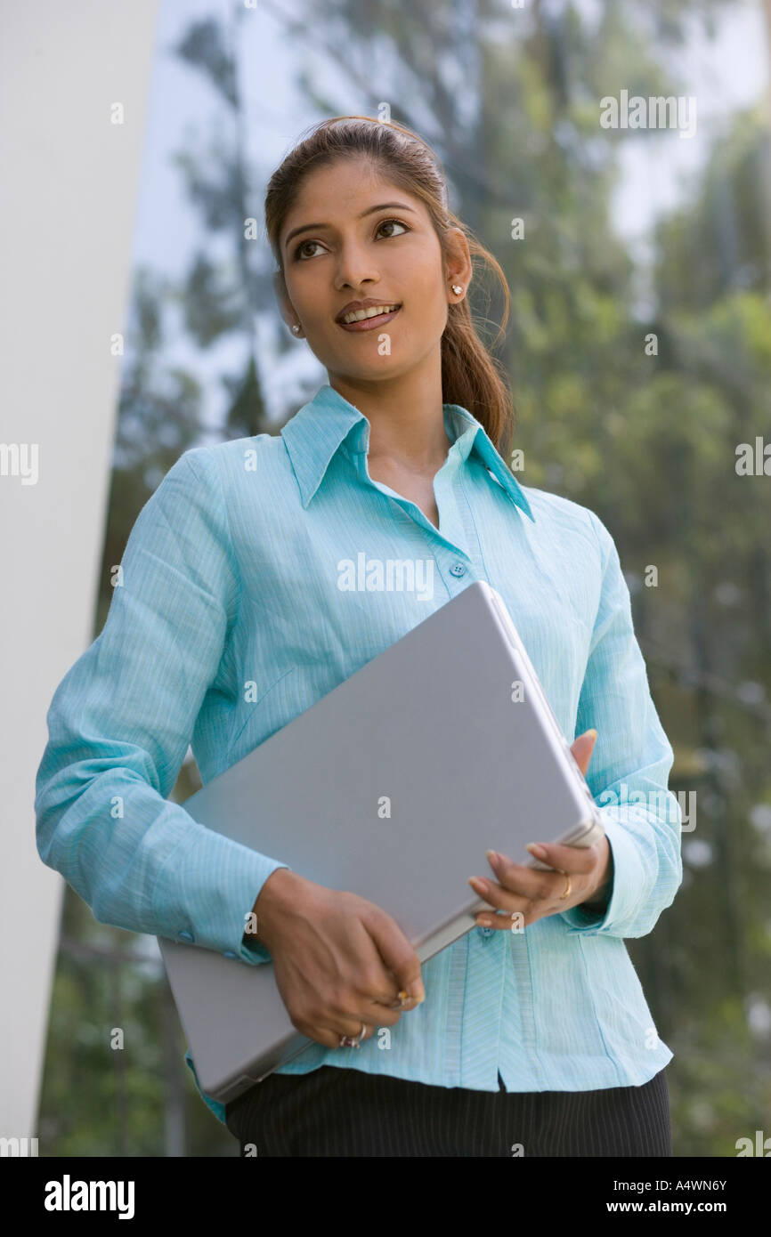 Businesswoman carrying laptop Stock Photo - Alamy