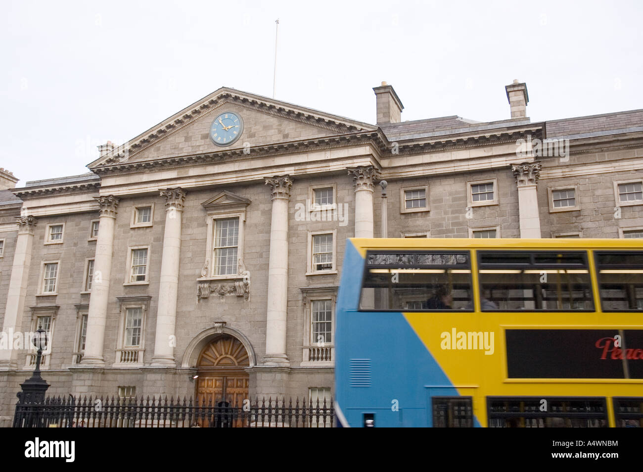 A double decker bus passes in front of Trinity College in Dublin ...