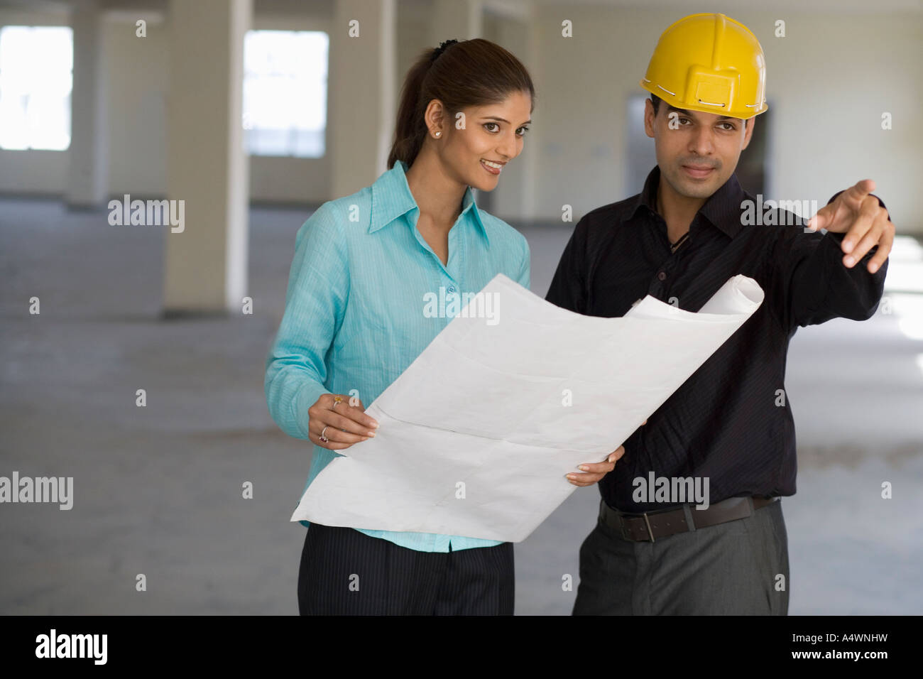 Businesspeople looking at blueprints Stock Photo - Alamy