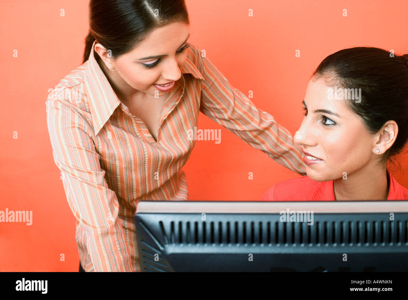 Businesswoman helping co-worker with computer Stock Photo - Alamy