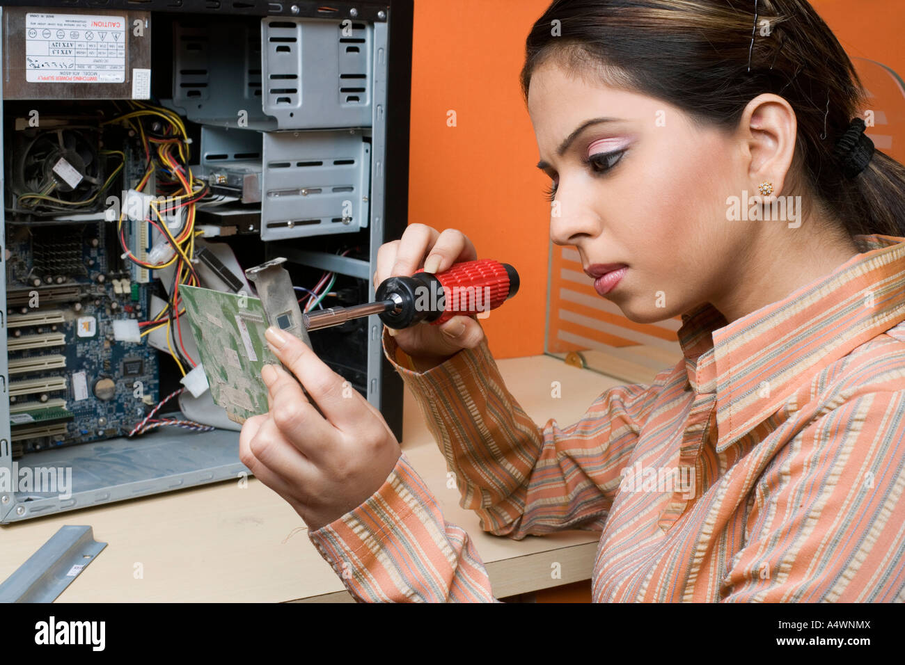 Businesswoman repairing computer Stock Photo - Alamy