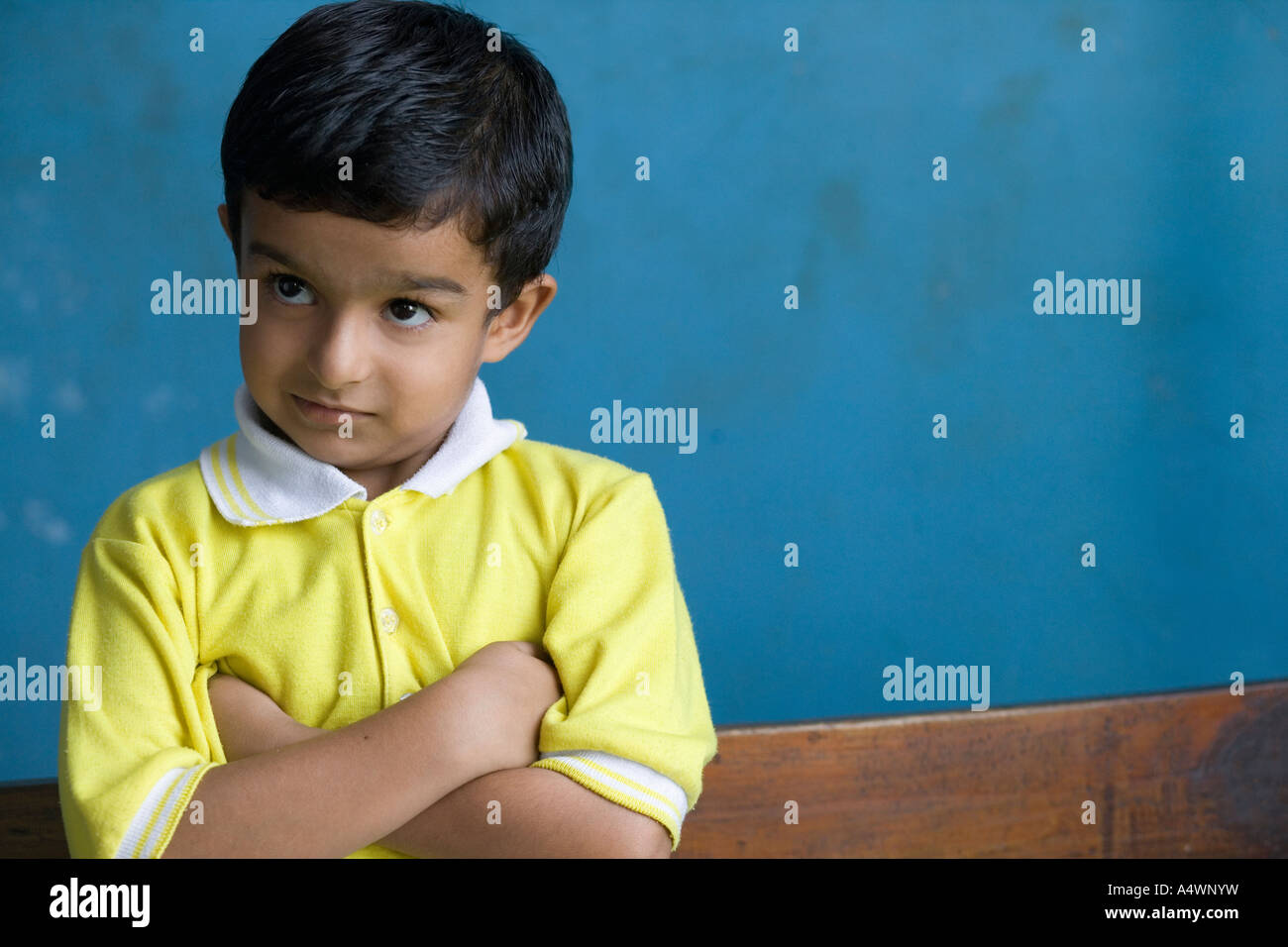 Young boy crossing arms Stock Photo - Alamy
