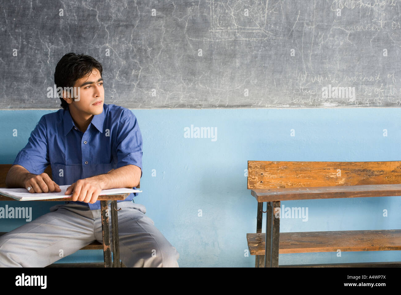 Male student sitting at desk Stock Photo - Alamy