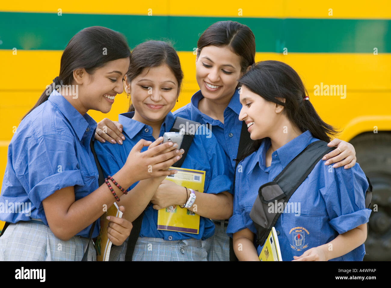 Female students crowding around cell phone Stock Photo - Alamy