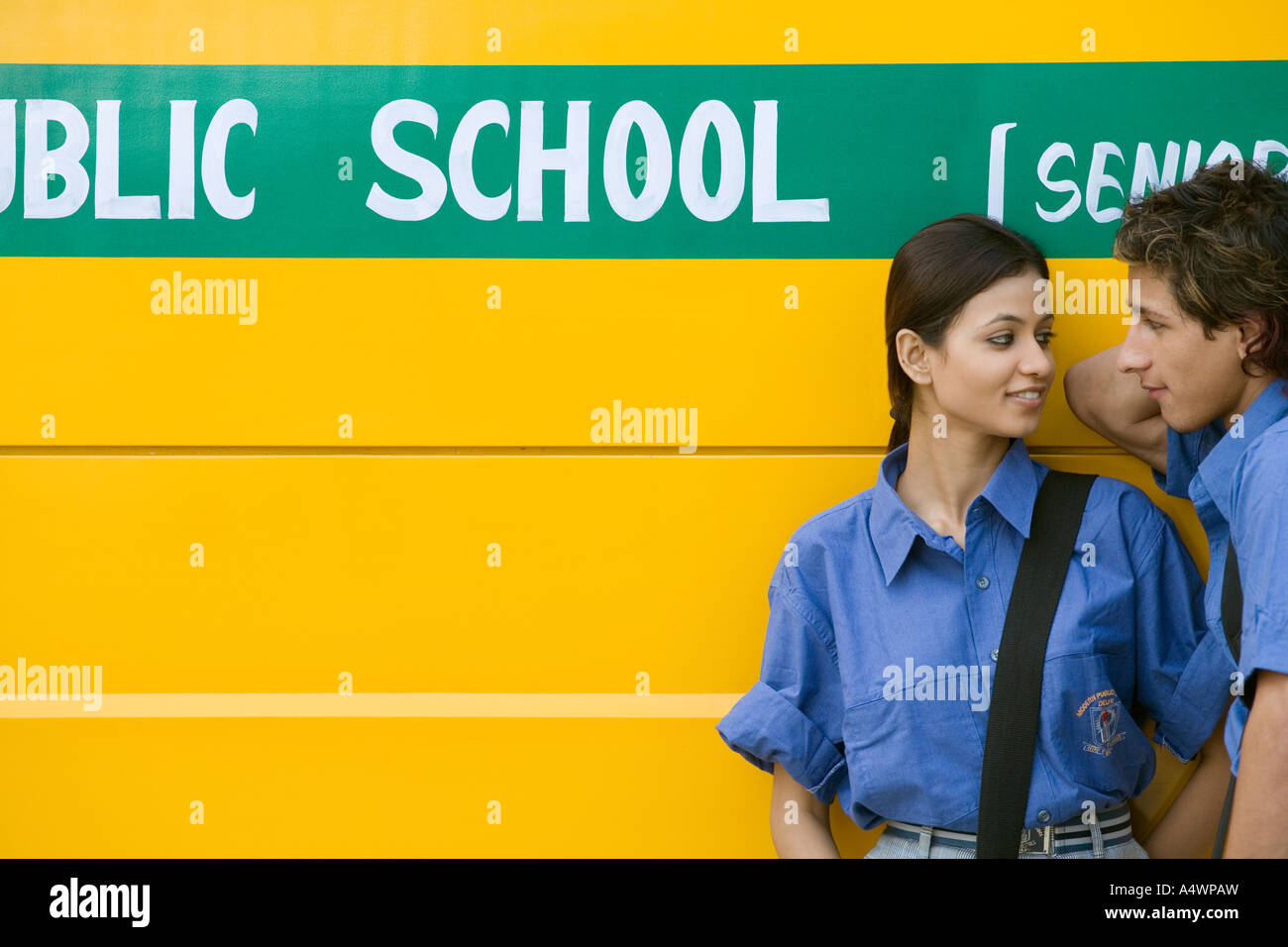 Student couple talking in front of school bus Stock Photo - Alamy