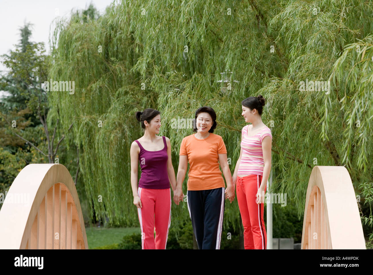 Mother and daughters walking over a bridge Stock Photo - Alamy