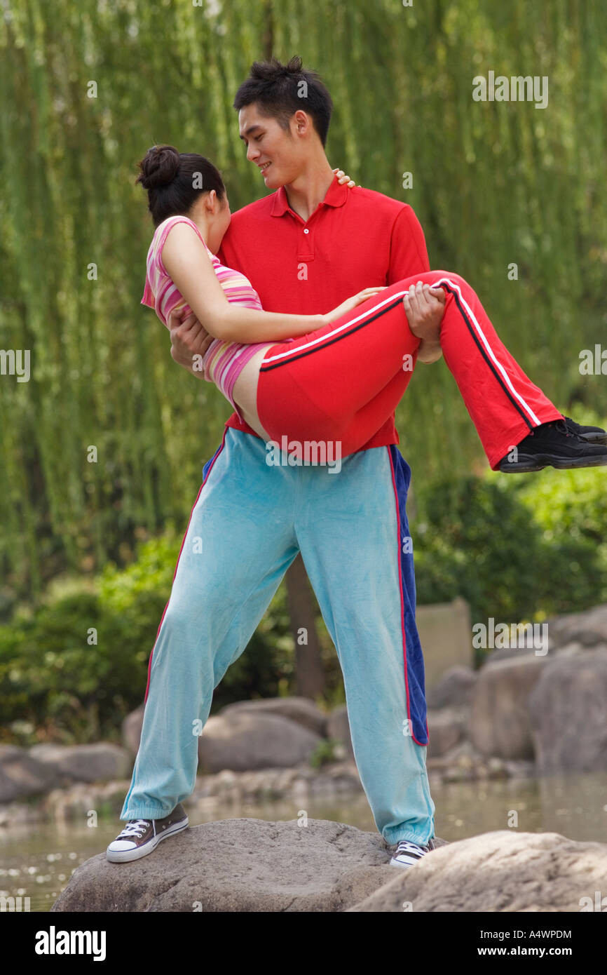 Young man carrying his girlfriend Stock Photo - Alamy